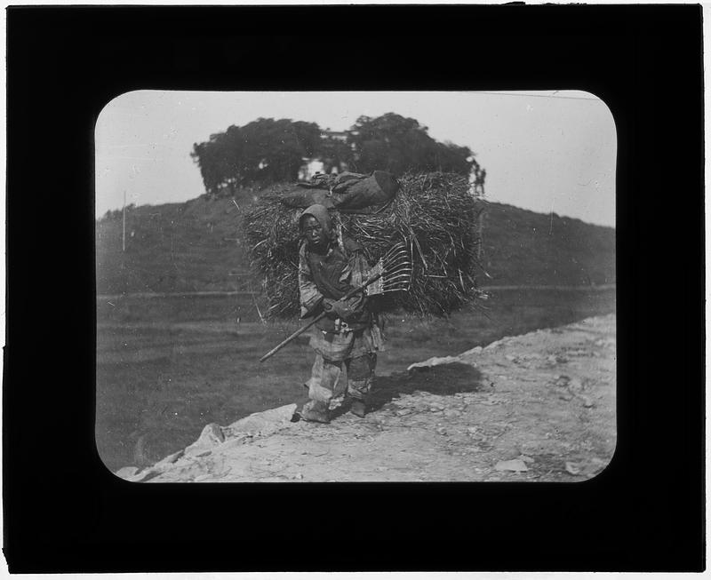 Person carrying a large bundle on their back - Digital Commonwealth