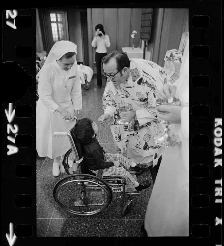 Crippled boy receives communion at orphanage mass, Brighton - Digital ...