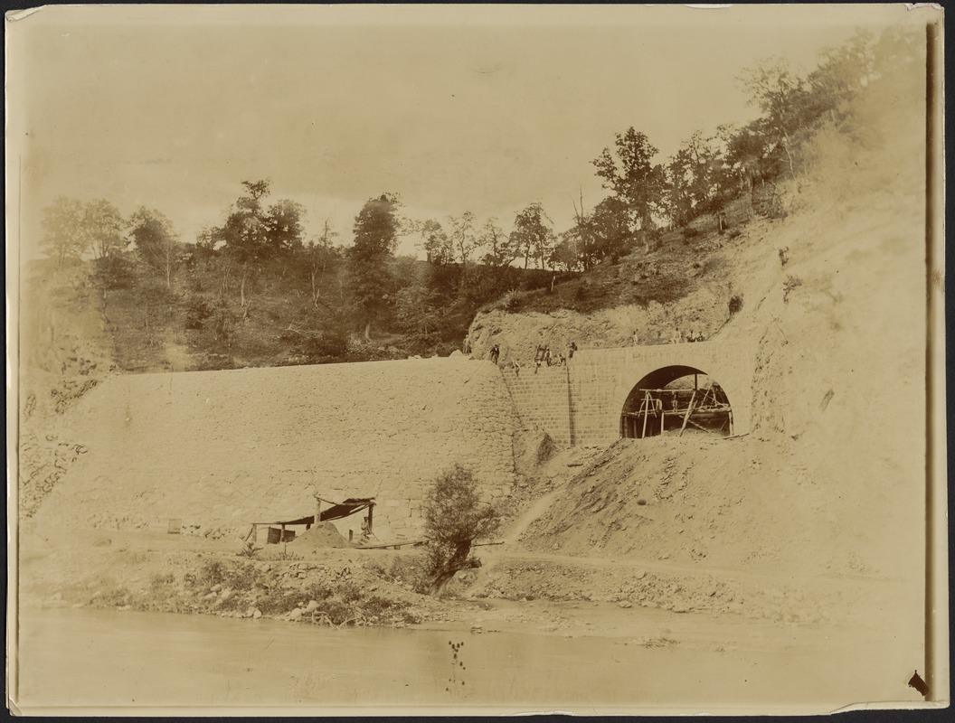 Construction of stone dam and bridge near river - Digital Commonwealth