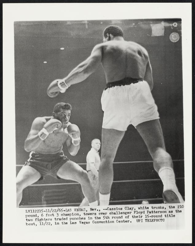 Cassius Clay, white trunks, the 210 pound, 6 foot 3 champion, towers ...