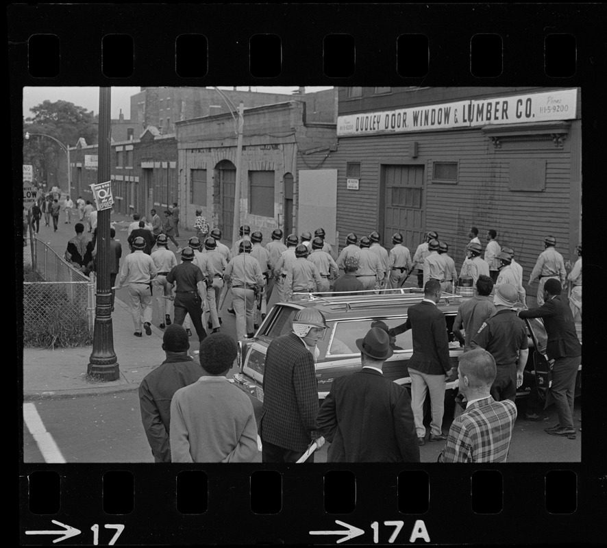 Riot police walking past Dudley Door Window & Lumber Co. in Roxbury ...