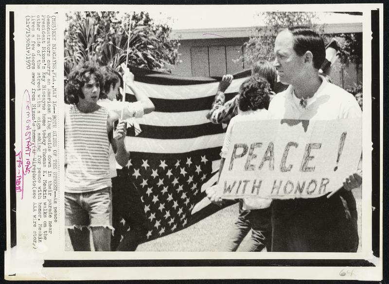 Both Sides of the Street--As peace demonstrators carry an American flag ...
