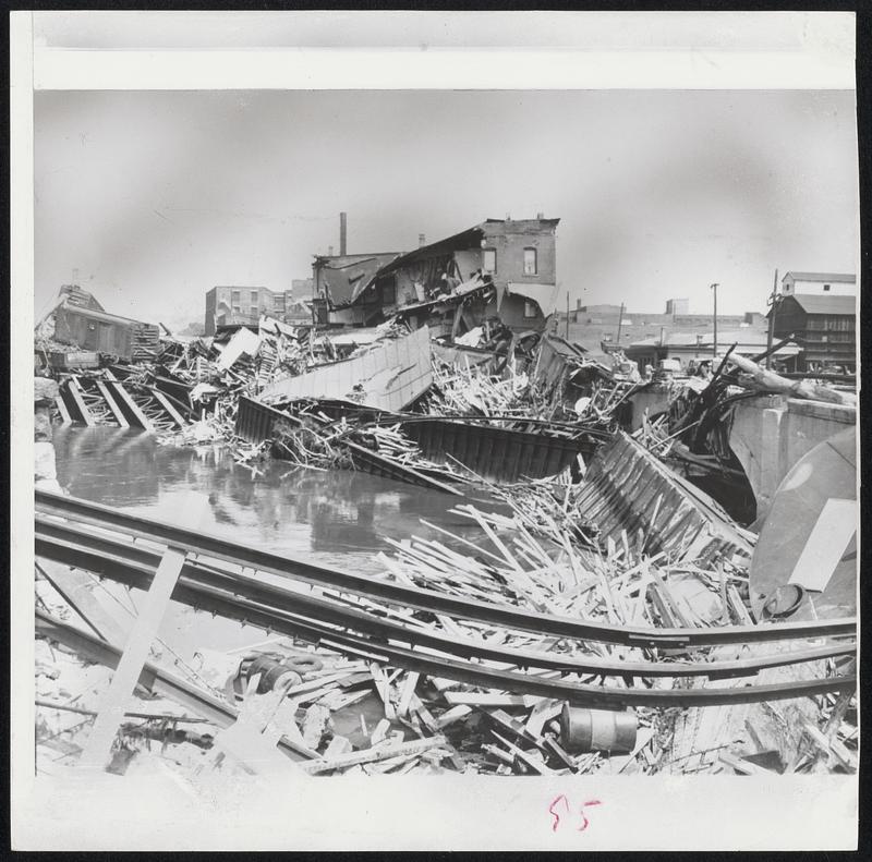 Battered freight cars, bent rails, splintered lumber, house furnishings ...