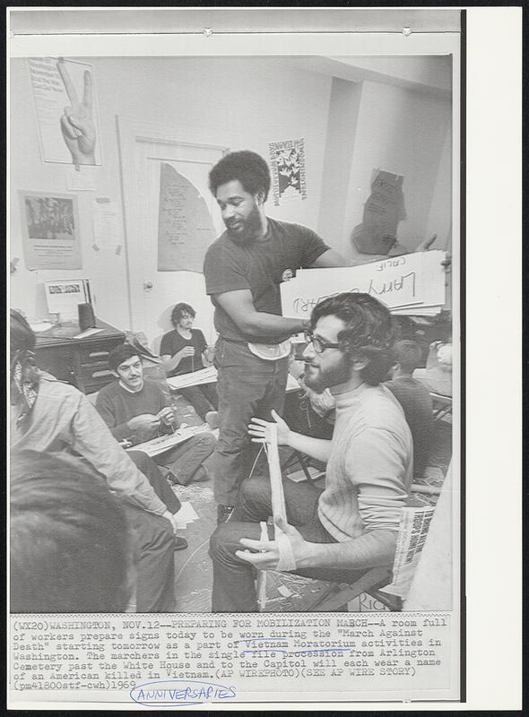 Preparing for Mobilization March--A room full of workers prepare signs ...