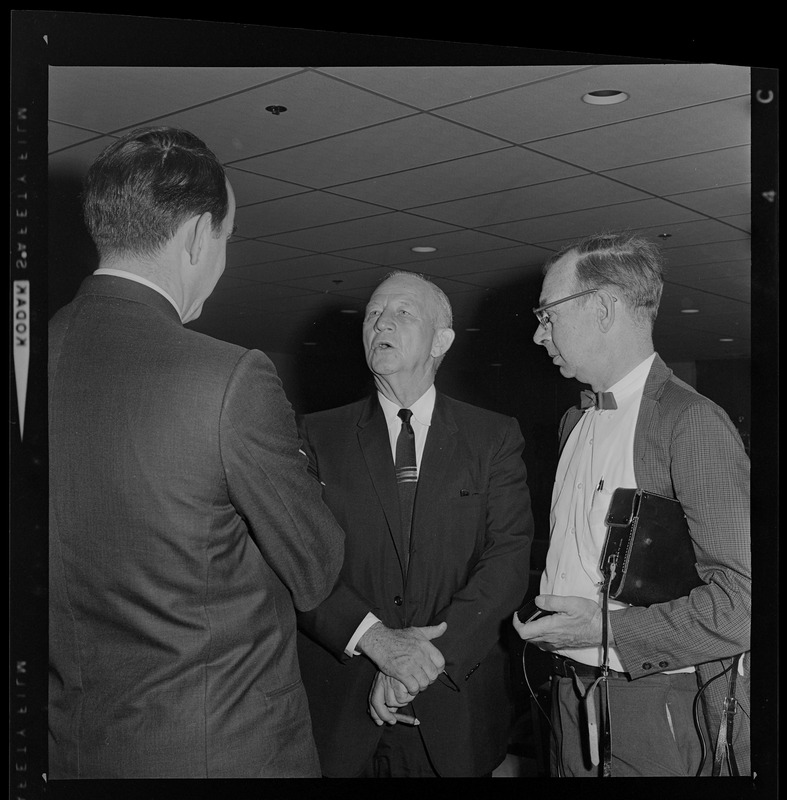 Three unidentified men at press conference with Senator Birch Bayh ...