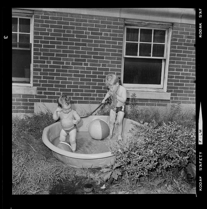 Two children playing in a wading pool - Digital Commonwealth