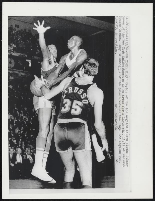 Elgin Baylor of the Los Angeles Lakers blocks Johnny Green of the New ...