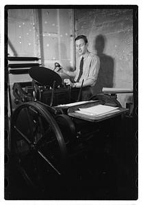 A man oiling a printing press - Digital Commonwealth