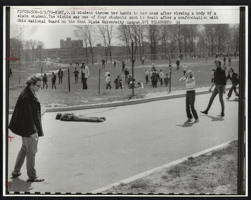 A student throws her hands to her head after viewing a body of a slain ...