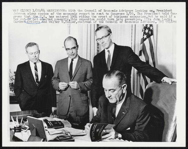 With the Council of Economic Advisers looking on, President Johnson ...