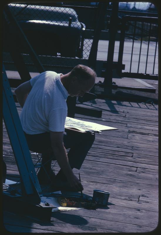 Artist reaching for paint on pier - Digital Commonwealth