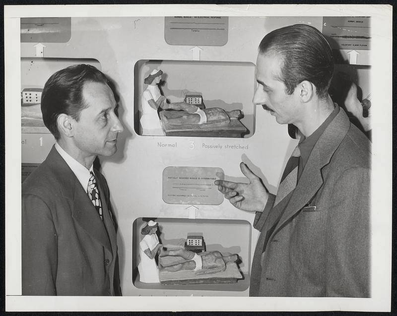 Two men examine physical therapy display - Digital Commonwealth
