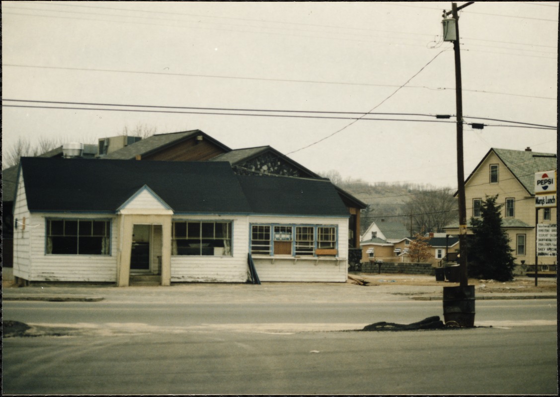 View from across the street of a wooden building with two windows ...