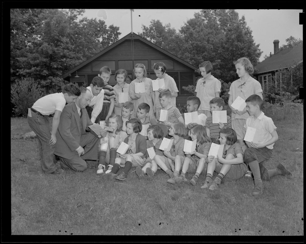 Edward J. Delaney showing U. S. defense savings stamps to children from ...