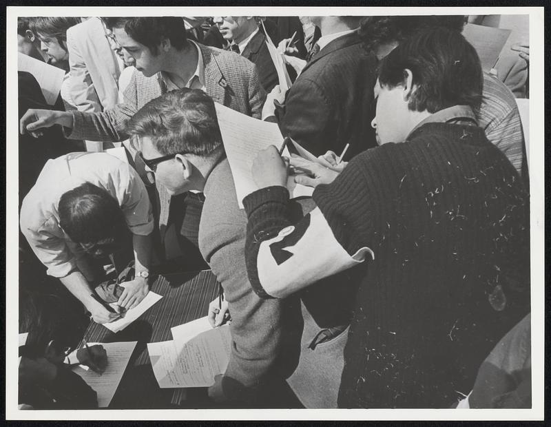 One Youth uses a friends back to sign draft resistance form, while ...