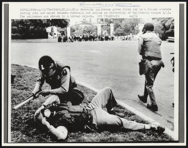 A Berkeley policeman gives first aid to a fallen comrade during anti ...