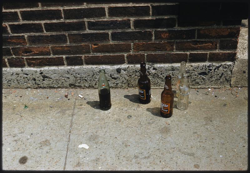 View of four bottles on the ground - Digital Commonwealth