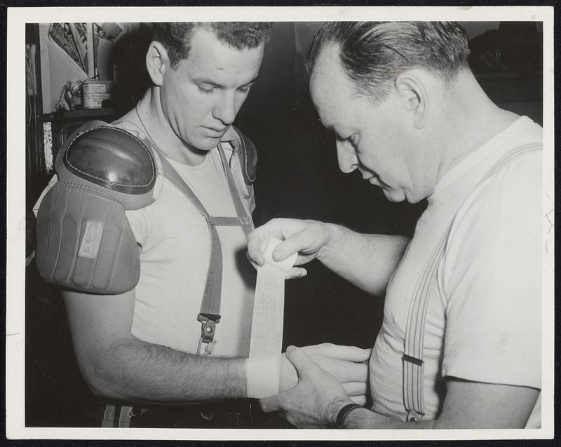 Ed Sandford gets his wrist taped by Win Green. - Digital Commonwealth