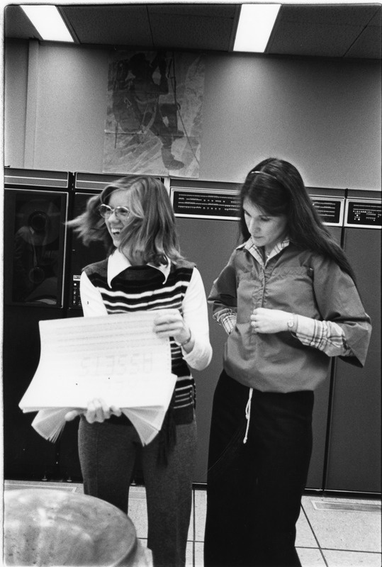 Two women with print from mainframe computer - Digital Commonwealth