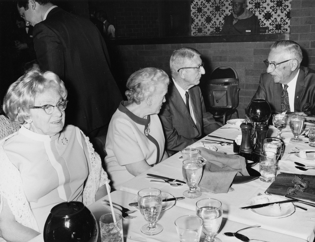 Group gathered at table for alumni event or reunion - Digital Commonwealth