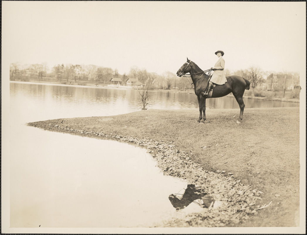 Woman sitting astride a horse by water - Digital Commonwealth