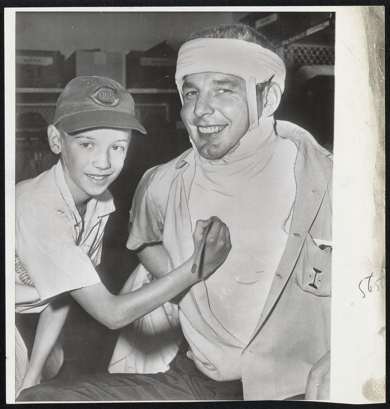 Chicago Cubs pitcher Paul Minner and 10-year-old Robert Robek pull a ...