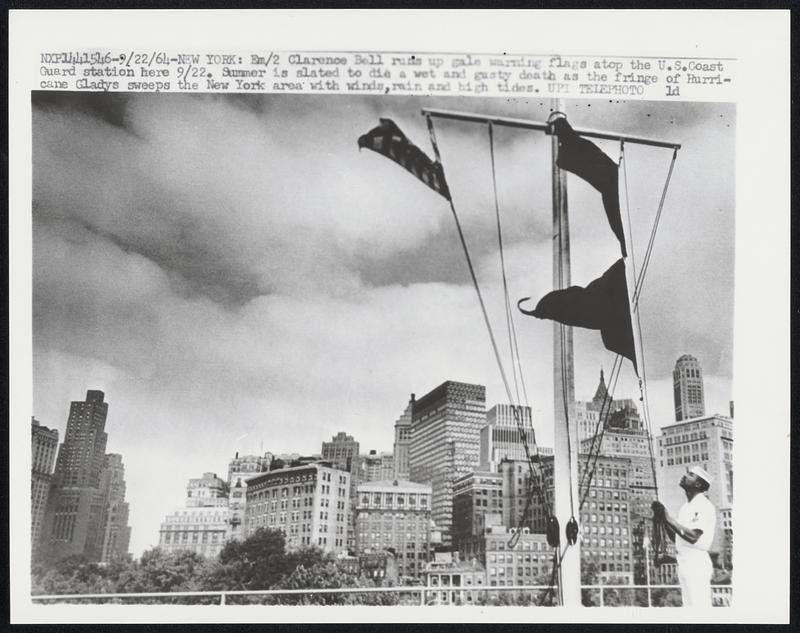 Em/2 Clarence Bell runs up gale warning flags atop the U.S. Coast Guard ...