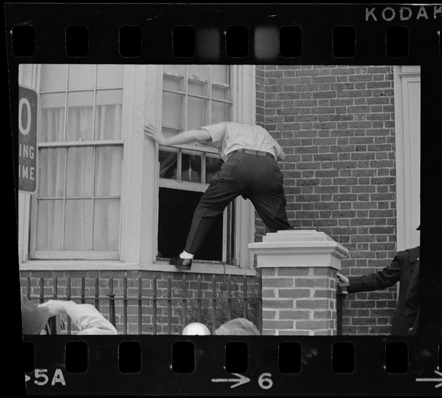 Police climb through window of house looking for suspects following an ...
