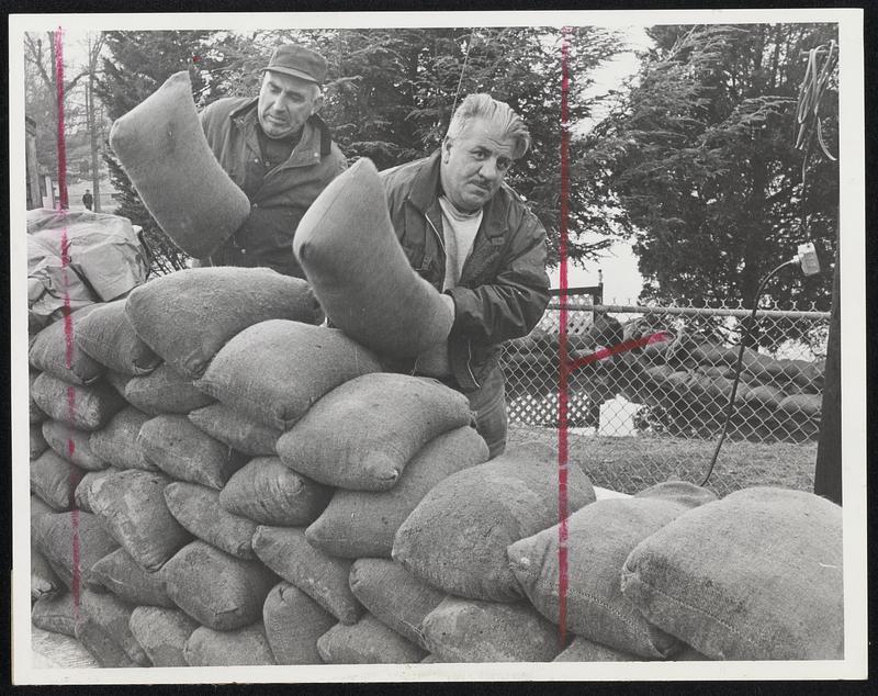 Taunton City workers, Frank De Brum and John Cambra, place sand bags at ...