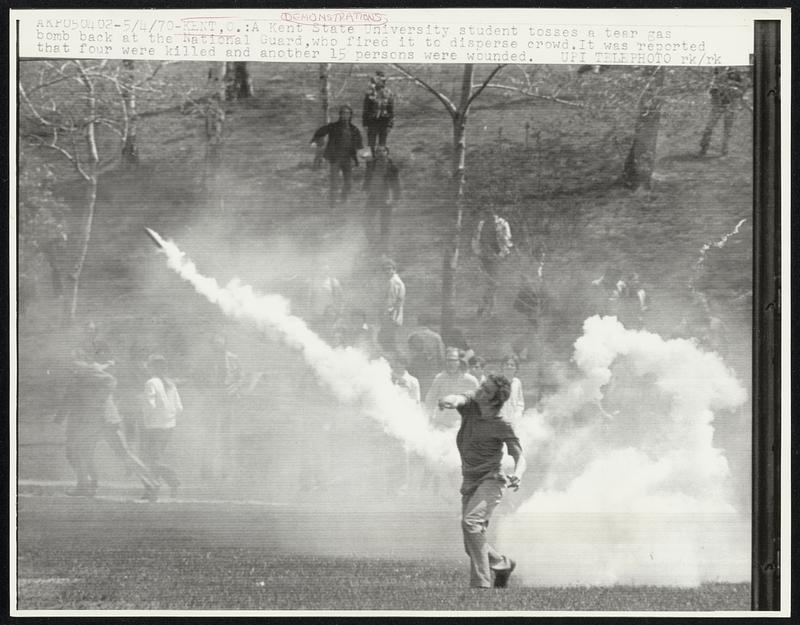 A Kent State University student tosses a tear gas bomb back at the ...