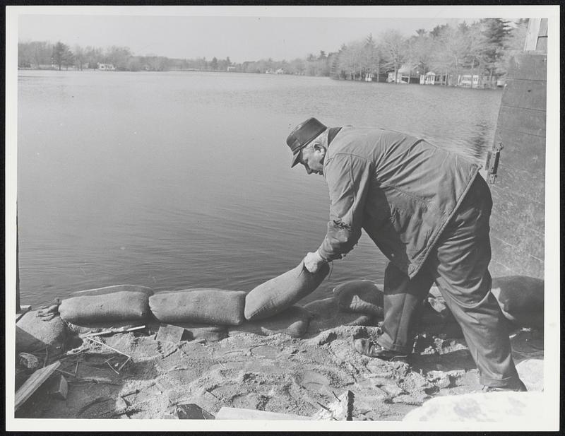 Raymond Benoit put sandbag in place at Morey's Dam - Digital Commonwealth