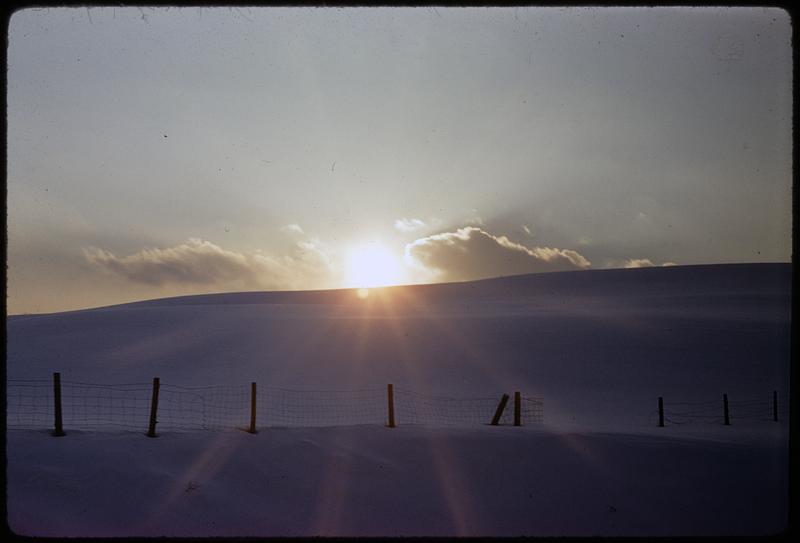Sun rising or setting over snow-covered hill - Digital Commonwealth