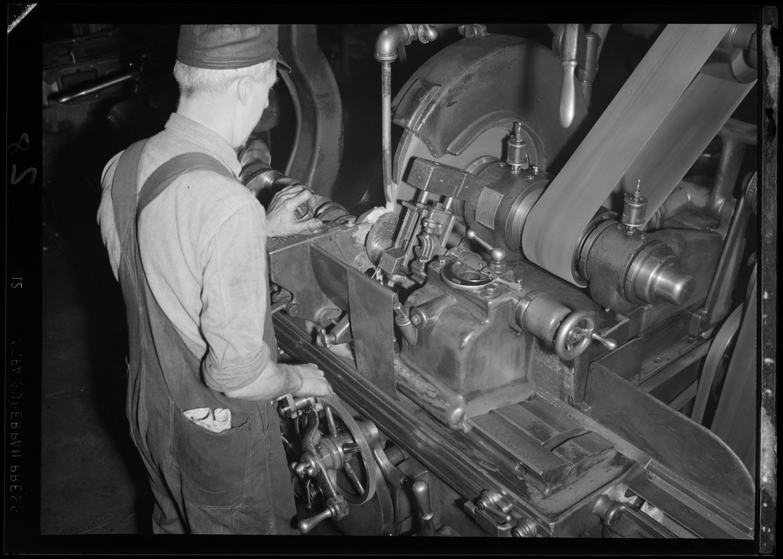 Man operating a machine in maintenance garage - Digital Commonwealth