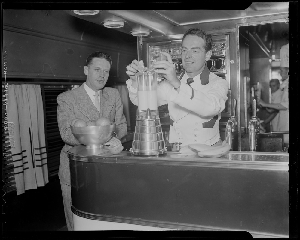 Fred Waring demonstrating a mixer as another man looks on - Digital ...