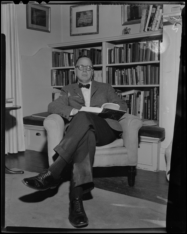 Arthur Schlesinger, Jr. seated in chair, with book - Digital Commonwealth