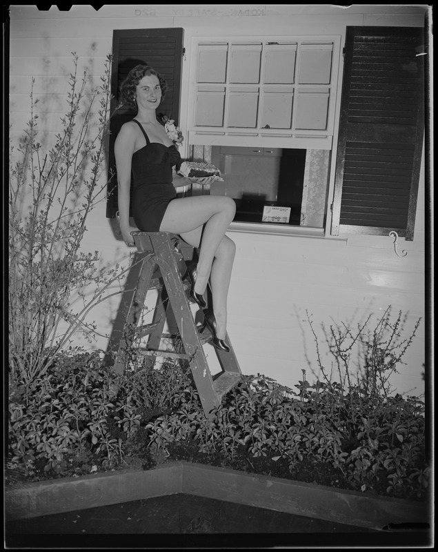 Mrs. Jean L. Smith, Mrs. Massachusetts, posing with a cake on a ladder ...