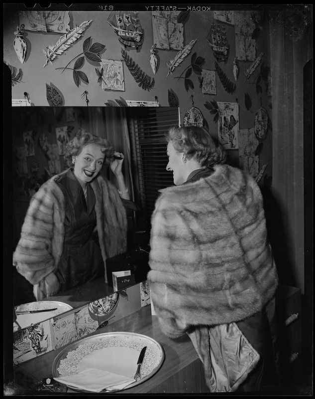 Christine Jorgenson primping hair in mirror - Digital Commonwealth