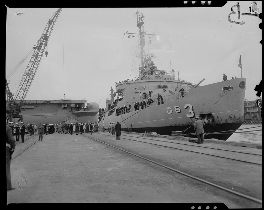 View of the U.S.S. Atka at the dock with men onboard - Digital Commonwealth