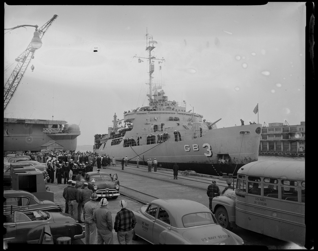 View of the U.S.S. ATKA at the dock from behind cars - Digital Commonwealth