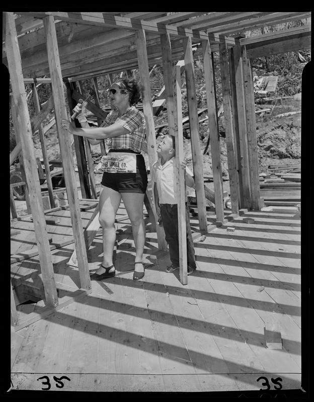 woman-and-a-child-putting-up-a-wooden-post-digital-commonwealth