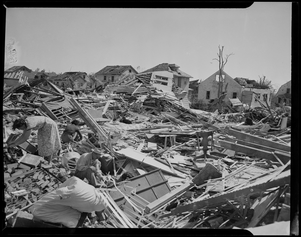 Man and three women digging through wreckage - Digital Commonwealth