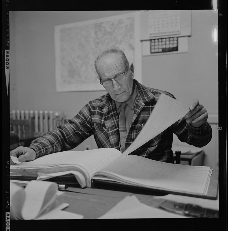 Albert Elwell looking at a ledger - Digital Commonwealth