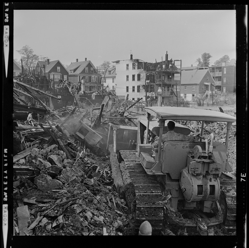 Man riding in a bulldozer on collapsed building debris - Digital ...