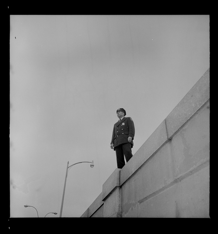 Police officer standing on top of wall - Digital Commonwealth