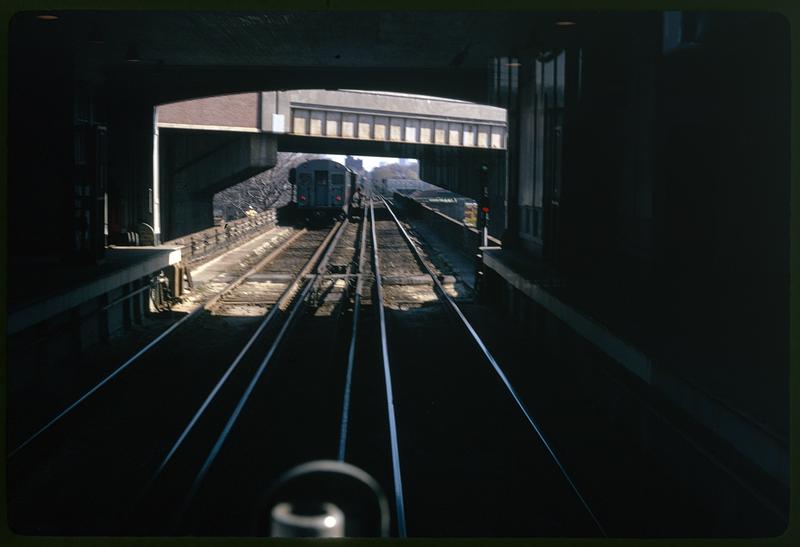 Looking down train tracks, a train on the left track - Digital Commonwealth