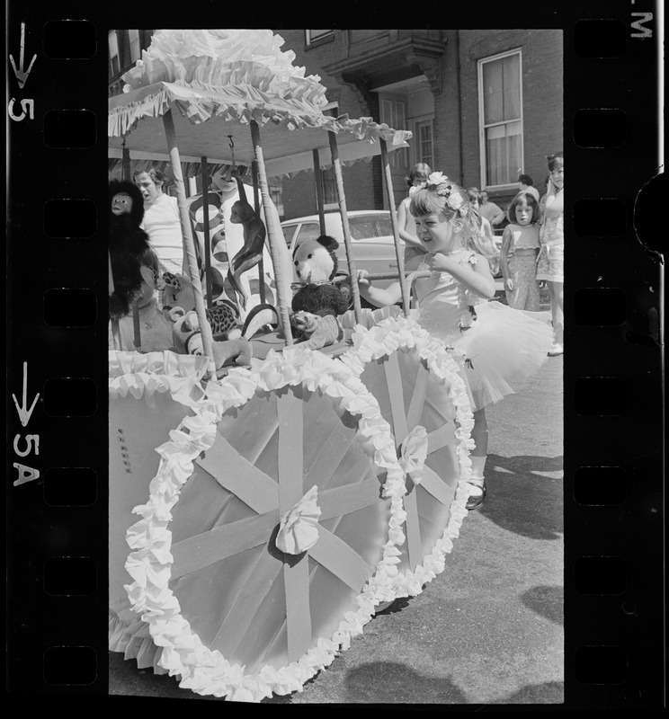 Girl holding onto decorated carriage filled with stuffed animals at ...