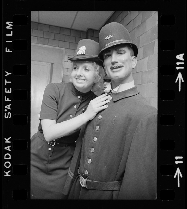 Female police officer poses with a male mannequin in police uniform ...