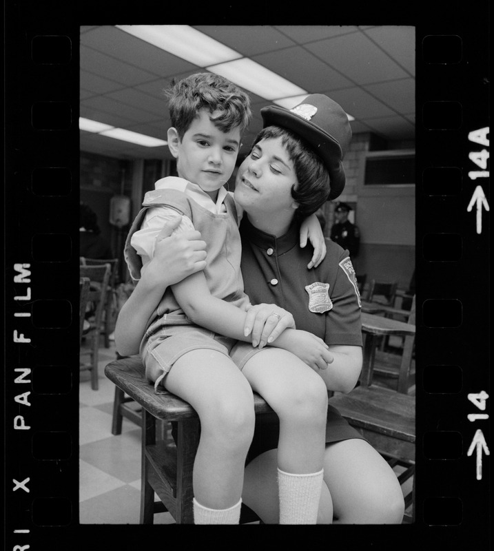 Female police officer hugging little boy - Digital Commonwealth