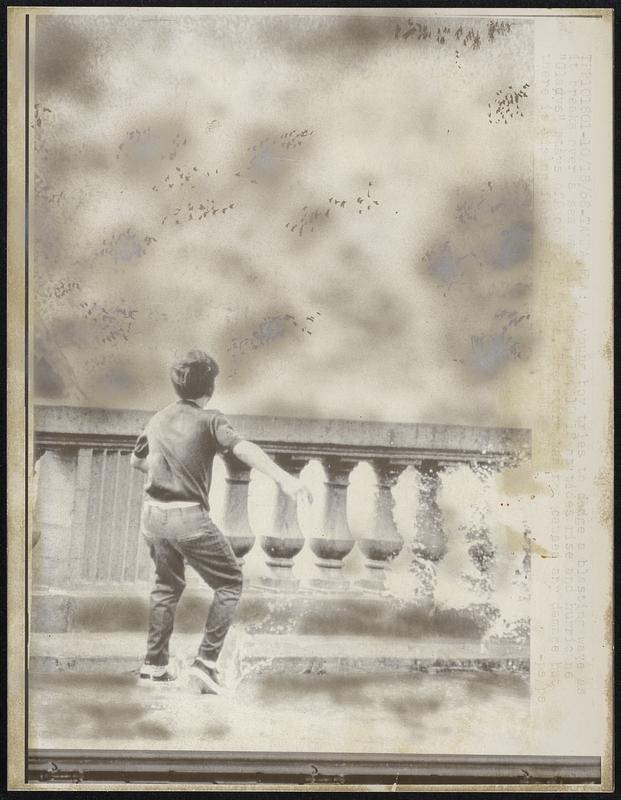 A young boy tries to dodge a blasting wave as it breaks over a sea wall ...