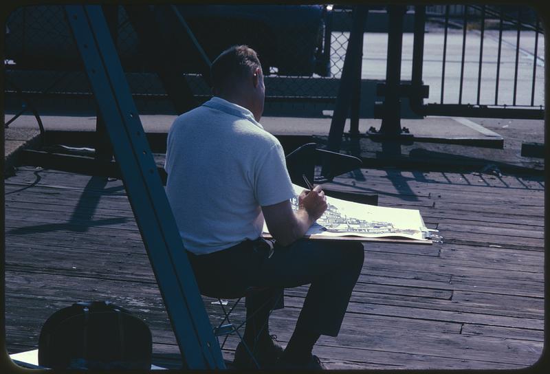Back view of artist sitting and working on pier - Digital Commonwealth